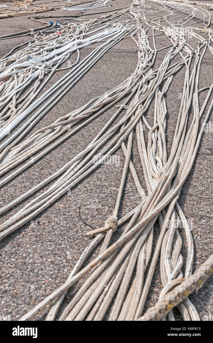 cables from fishing nets spread out on the harbour quay Stock Photo - Alamy