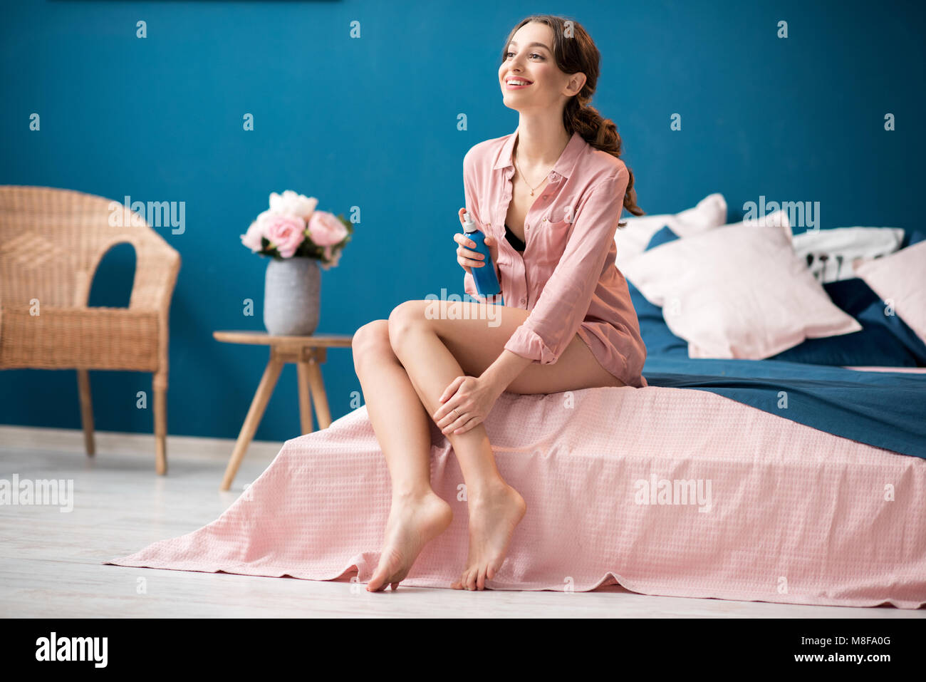 Woman applying skin lotion indoors Stock Photo - Alamy