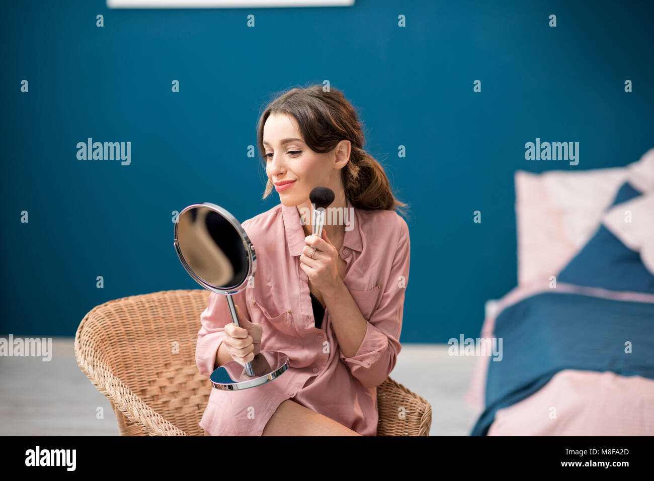 Woman applying cosmetics indoors Stock Photo - Alamy