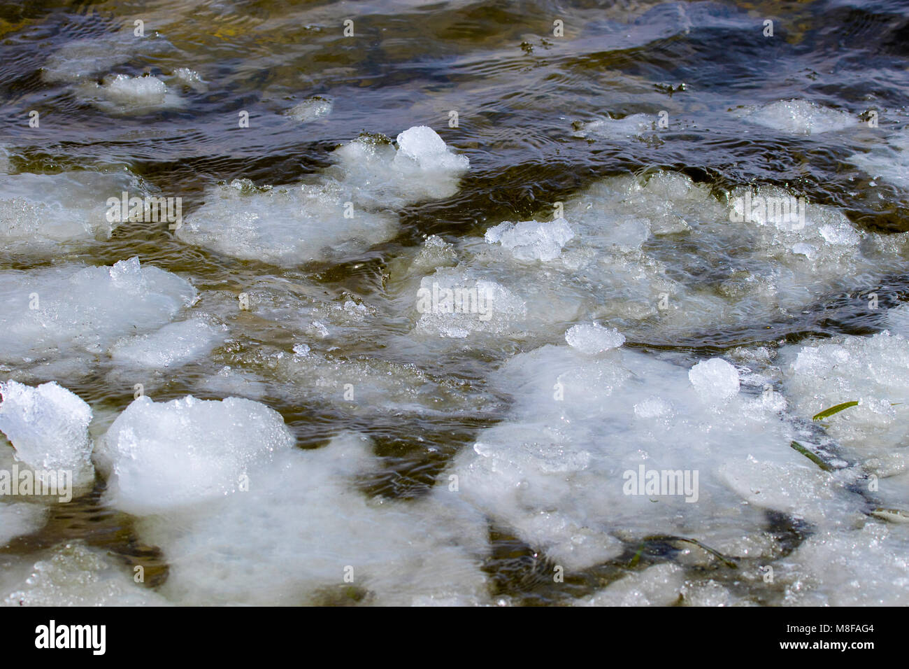 an image of melting snow floats along a small river Stock Photo - Alamy