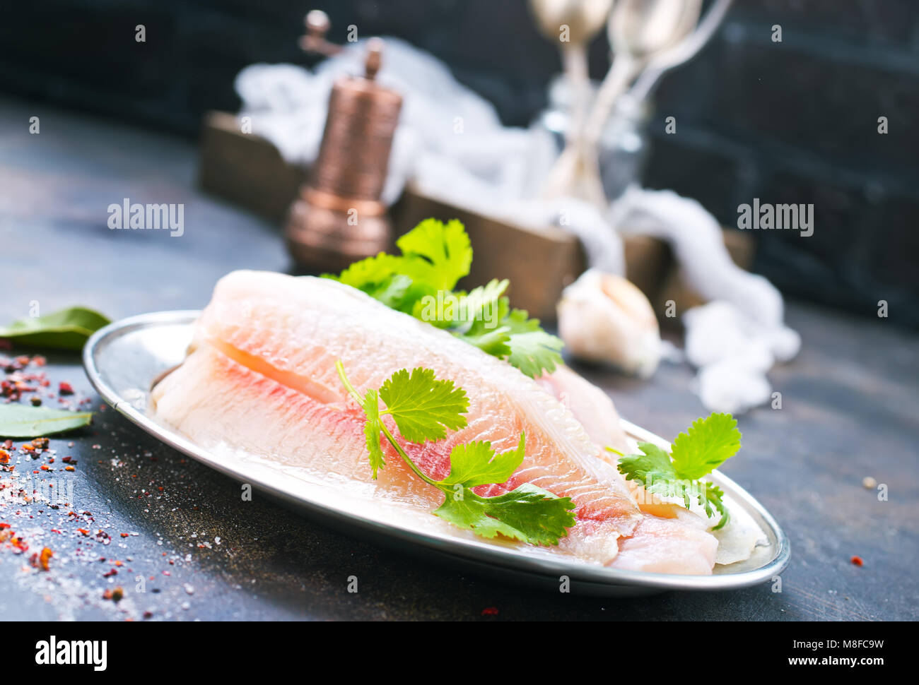raw fish fillet with aroma spice on plate Stock Photo - Alamy