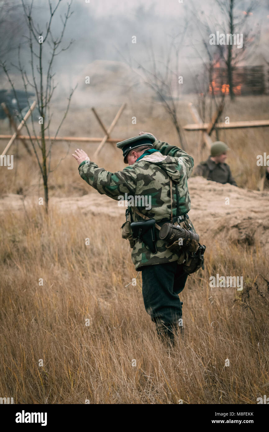 A German soldier of World War II with his arms raised surrenders to ...
