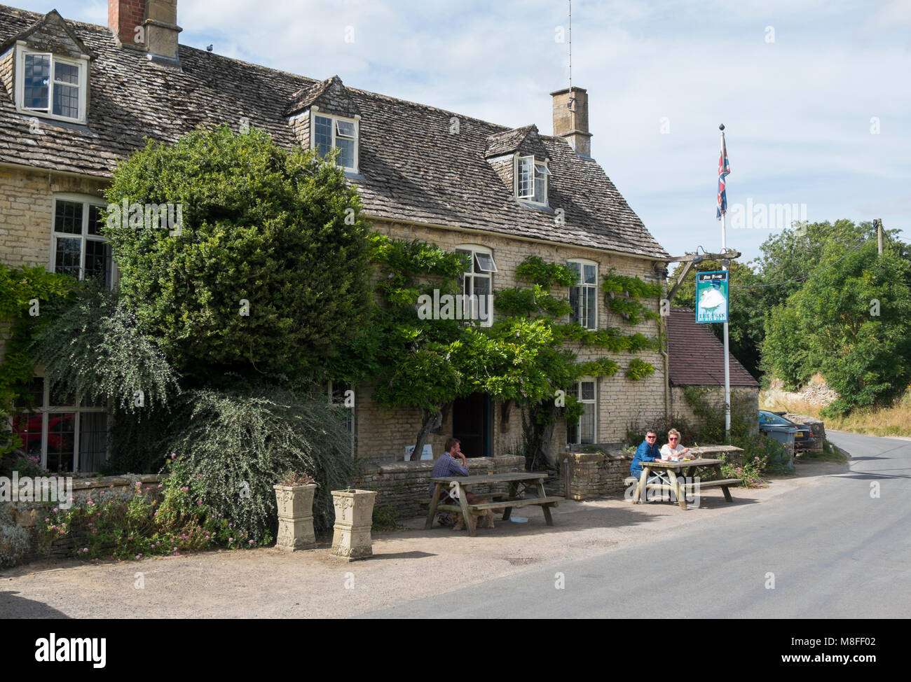 People enjoying a drink by the river Swin outside The Swan Pub at ...