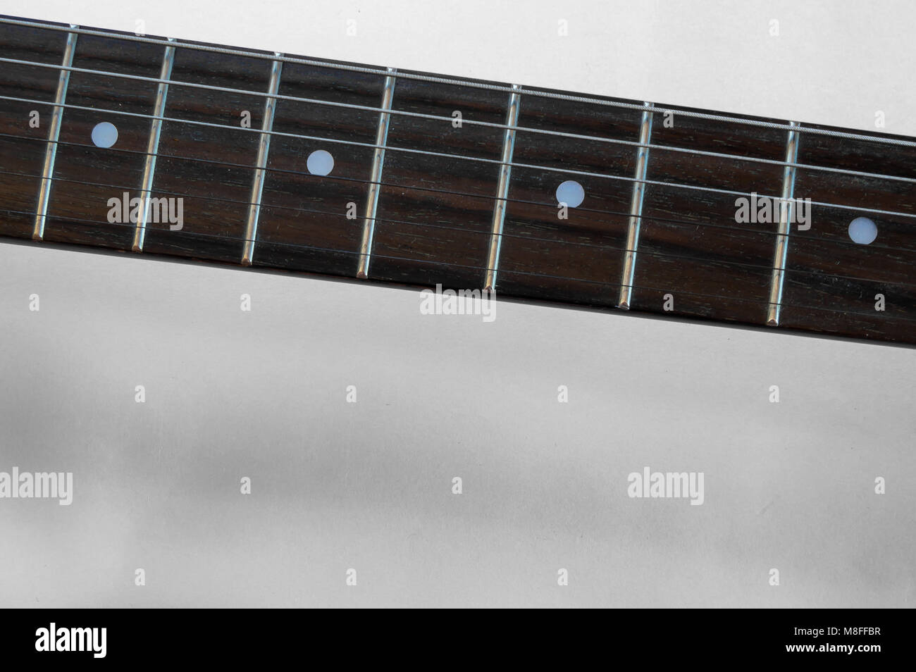 Neck and frets of a electric guitar isolated on white background ...