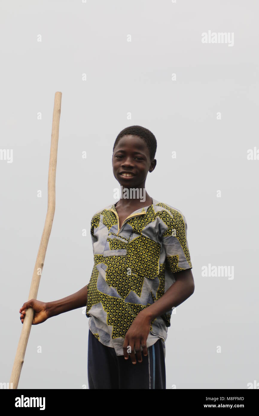 Boy stands in a boat to paddle over the lake Stock Photo - Alamy