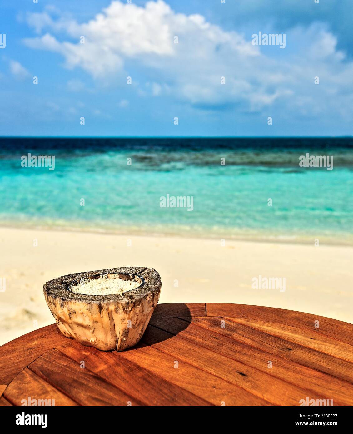 Ashtray with coral sand is on a beach table Stock Photo - Alamy