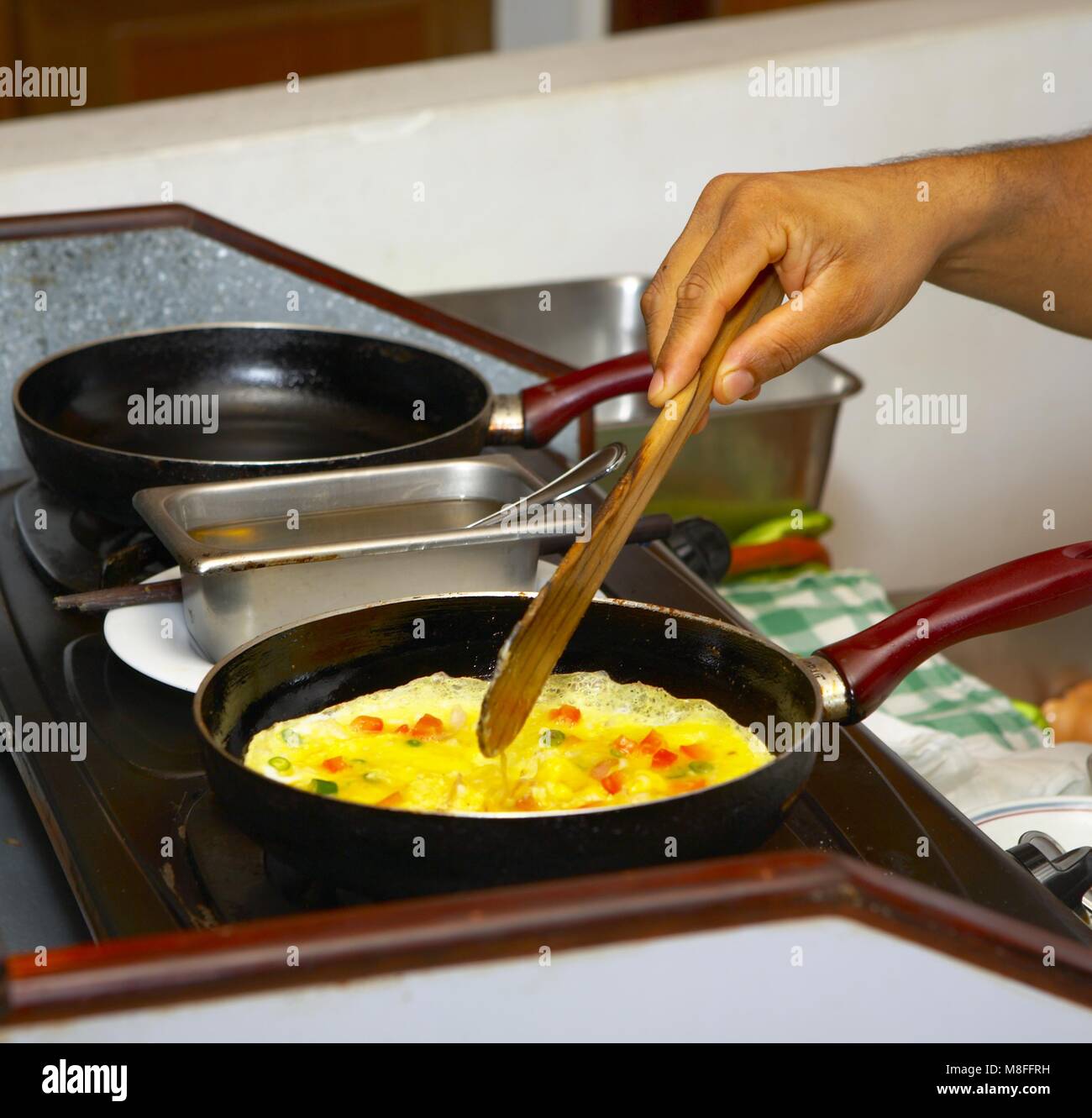 Chef is cooking omelet with tomato Stock Photo - Alamy