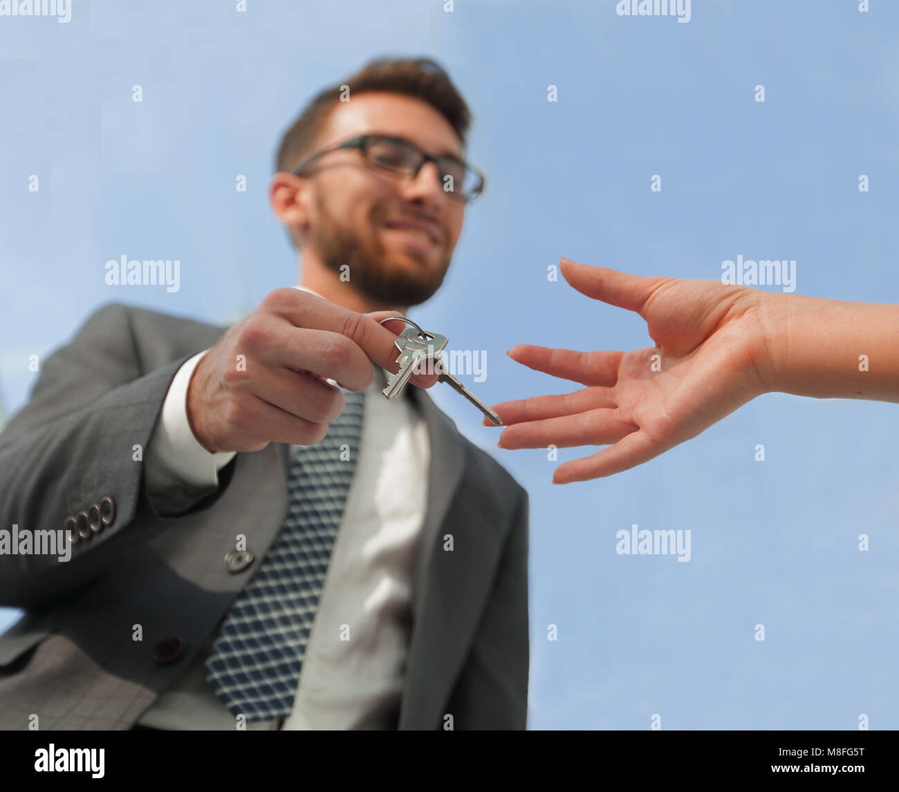 Cropped image of estate agent giving house keys to man in office Stock ...