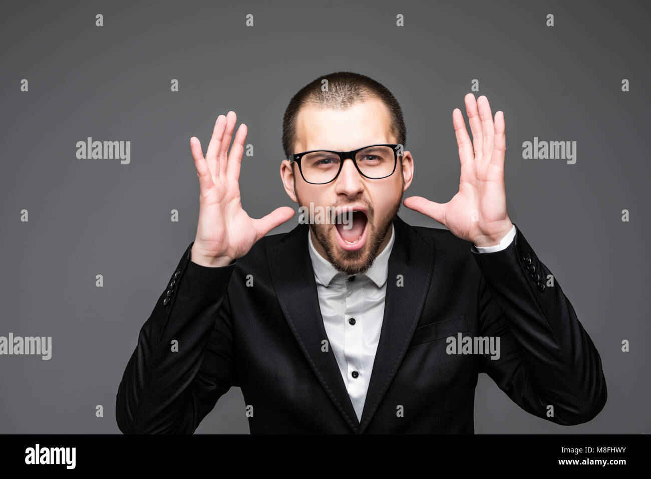 man in business suit holding his head and screaming Stock Photo - Alamy