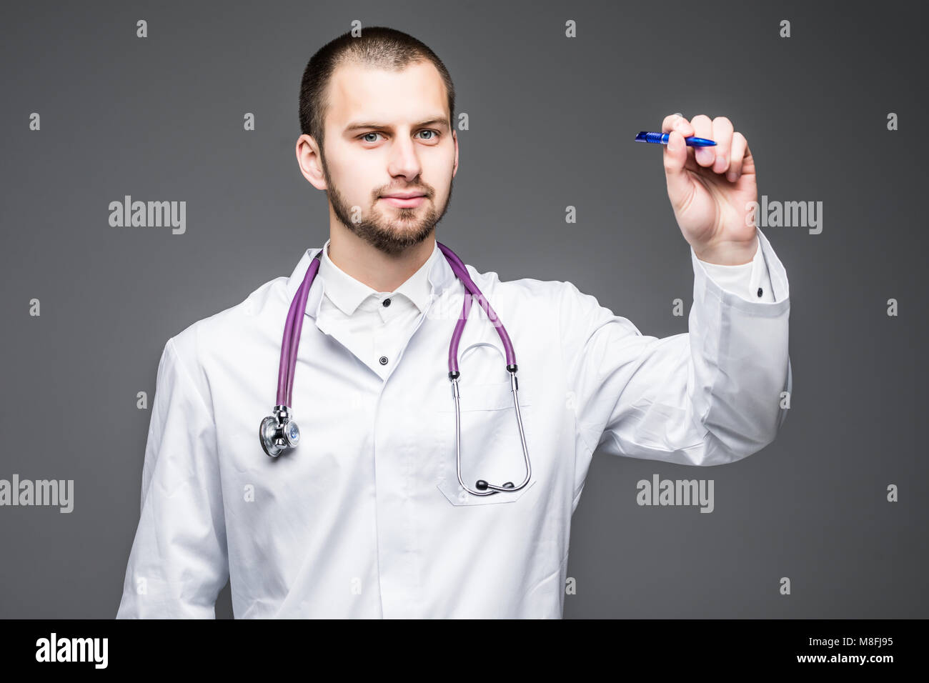 male doctor writing something on screen isolated over gray Stock Photo ...