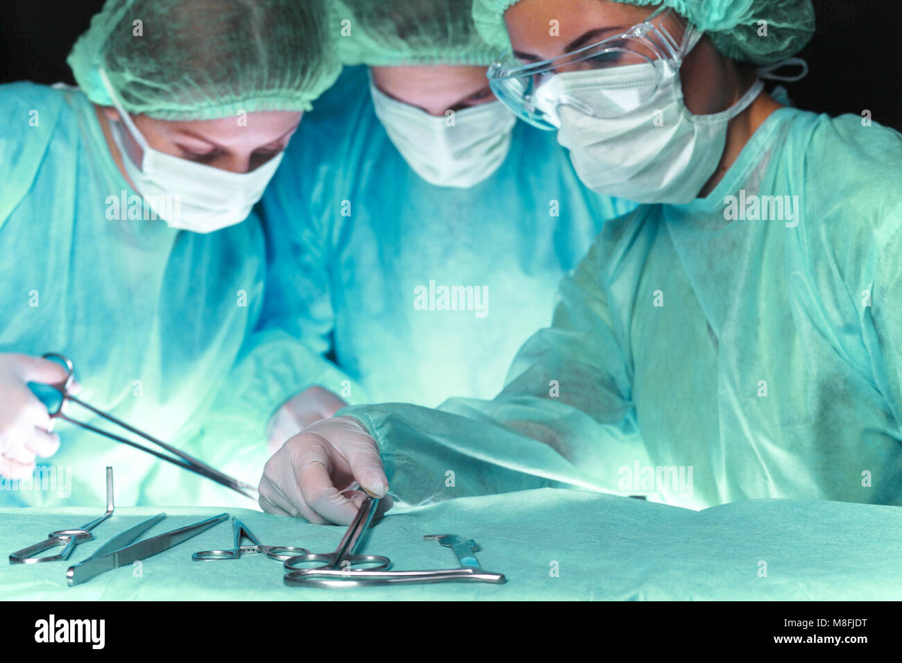 Group of surgeons in masks performing operation. Scene of operation ...