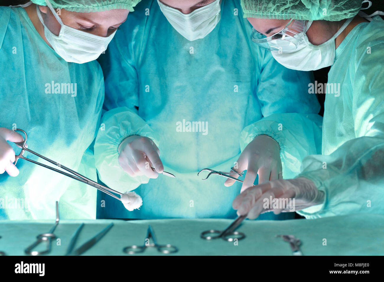 Group of surgeons in masks performing operation. Scene of operation ...