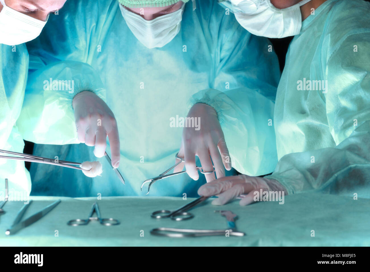 Group of surgeons in masks performing operation. Scene of operation ...