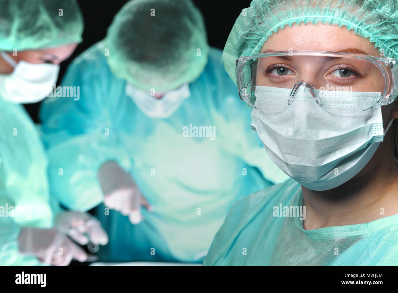 Closeup of surgeons performing operation. Focus on female doctor ...