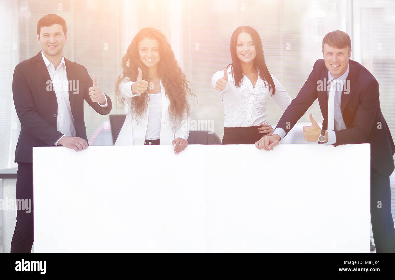 business team holding blank white banner Stock Photo - Alamy
