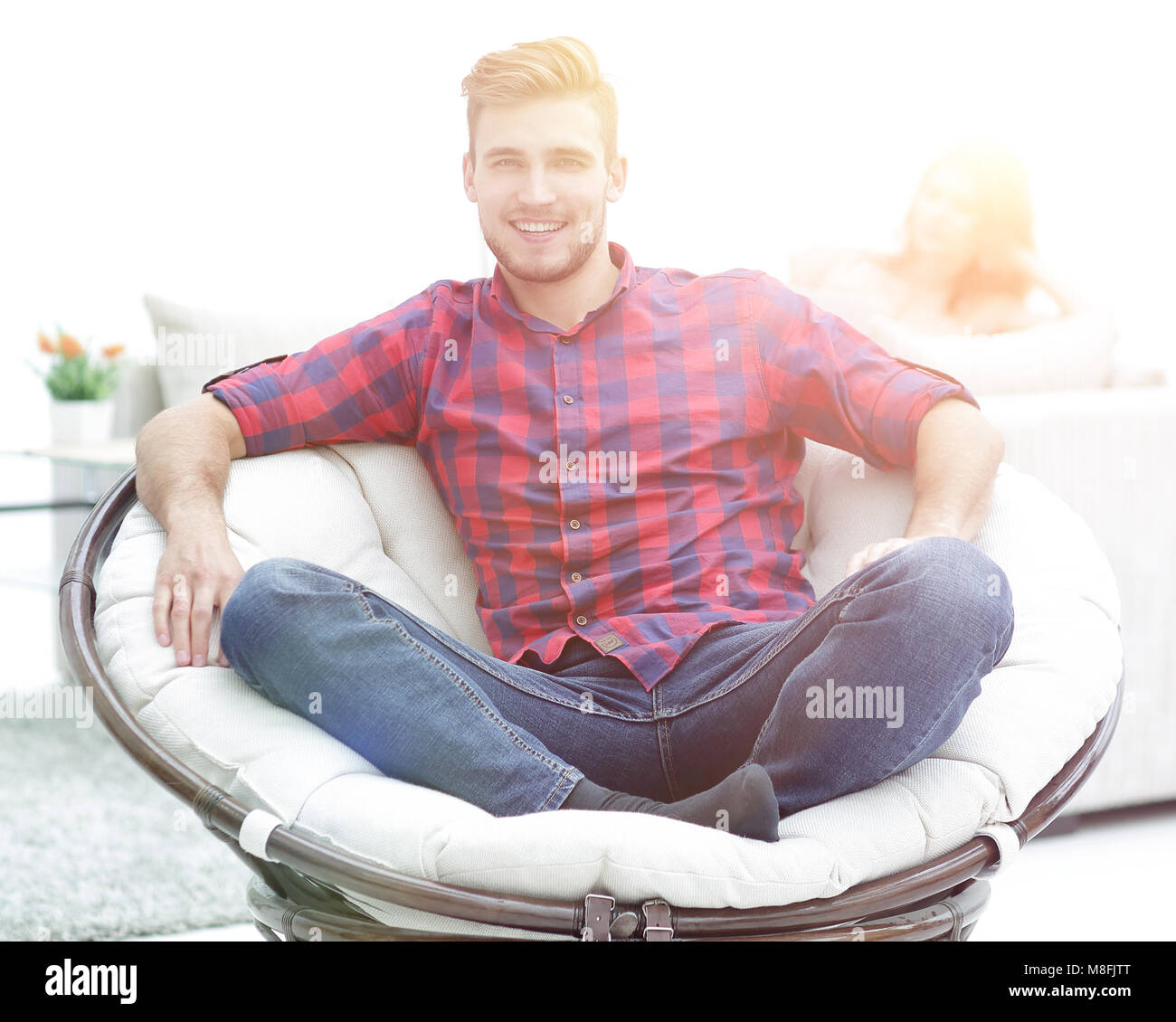 modern young man sitting in a big round chair on blurred backgro Stock ...