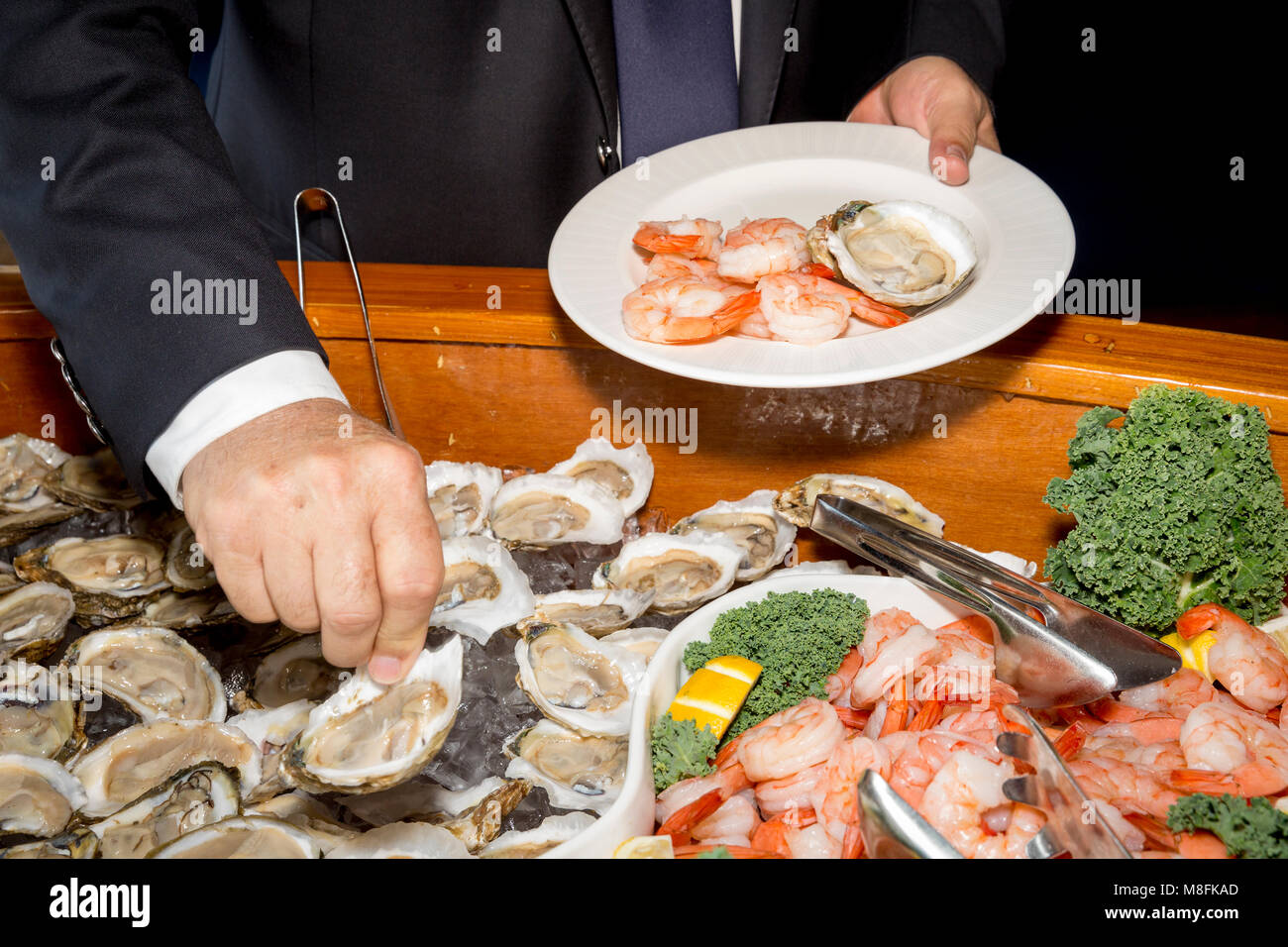 Man dishing up seafood at a Yacht Club brunch, Naples, Florida, USA ...