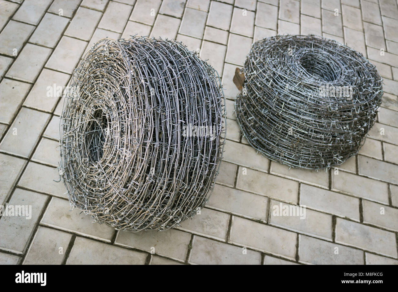 Bay of barbed wire on the sidewalk Stock Photo - Alamy