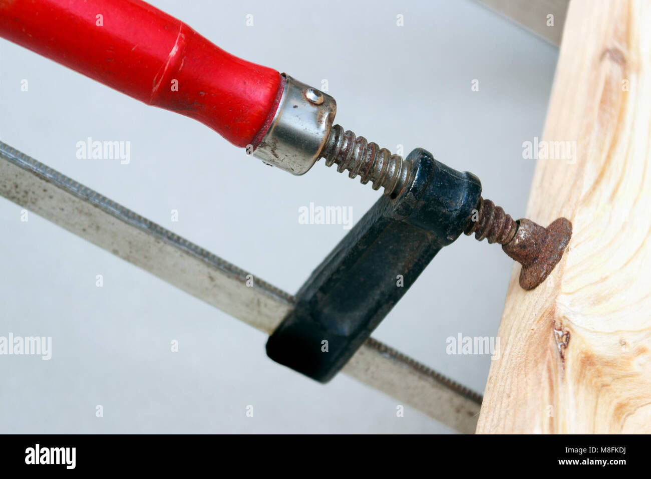 Old rusty clamp with red handle in the work Stock Photo - Alamy