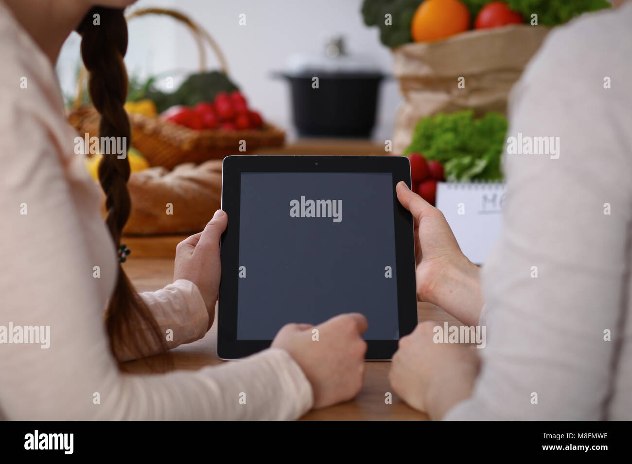 Closeup of human hands cooking in kitchen. Women discuss a menu using ...