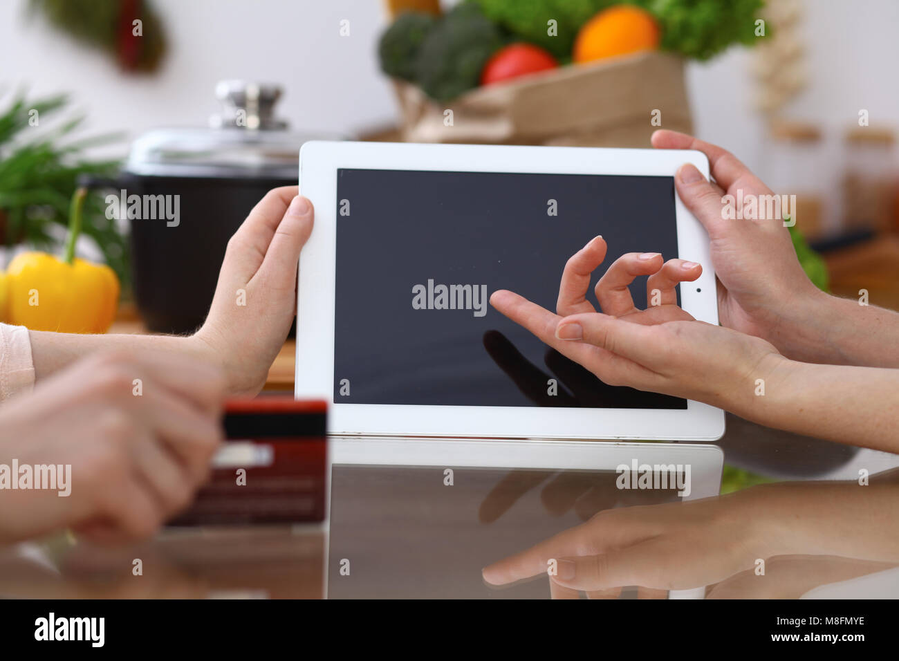 Closeup of human hands cooking in kitchen. Women discuss a menu using ...