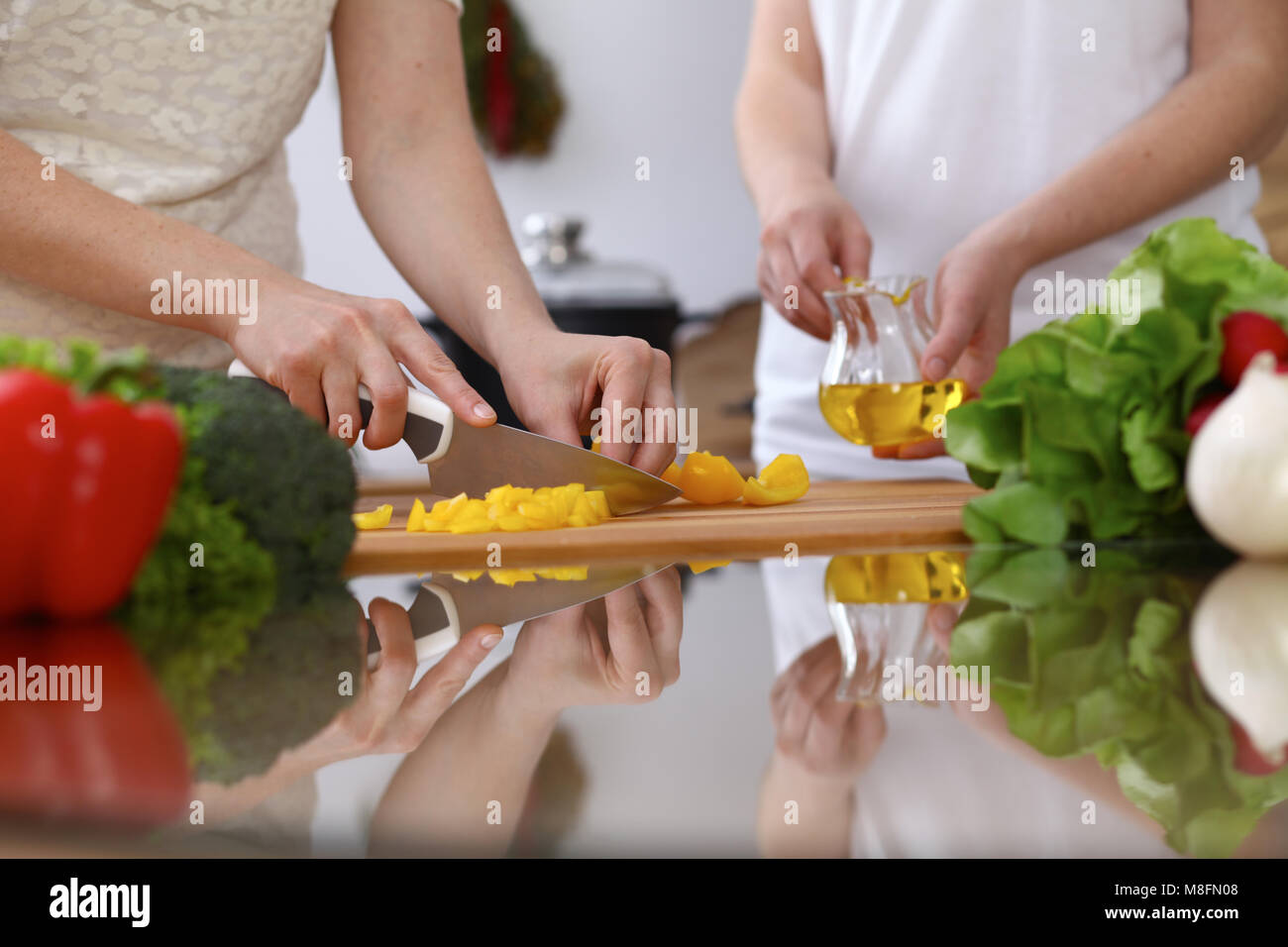Closeup of human hands cooking in kitchen. Mother and daughter or two ...