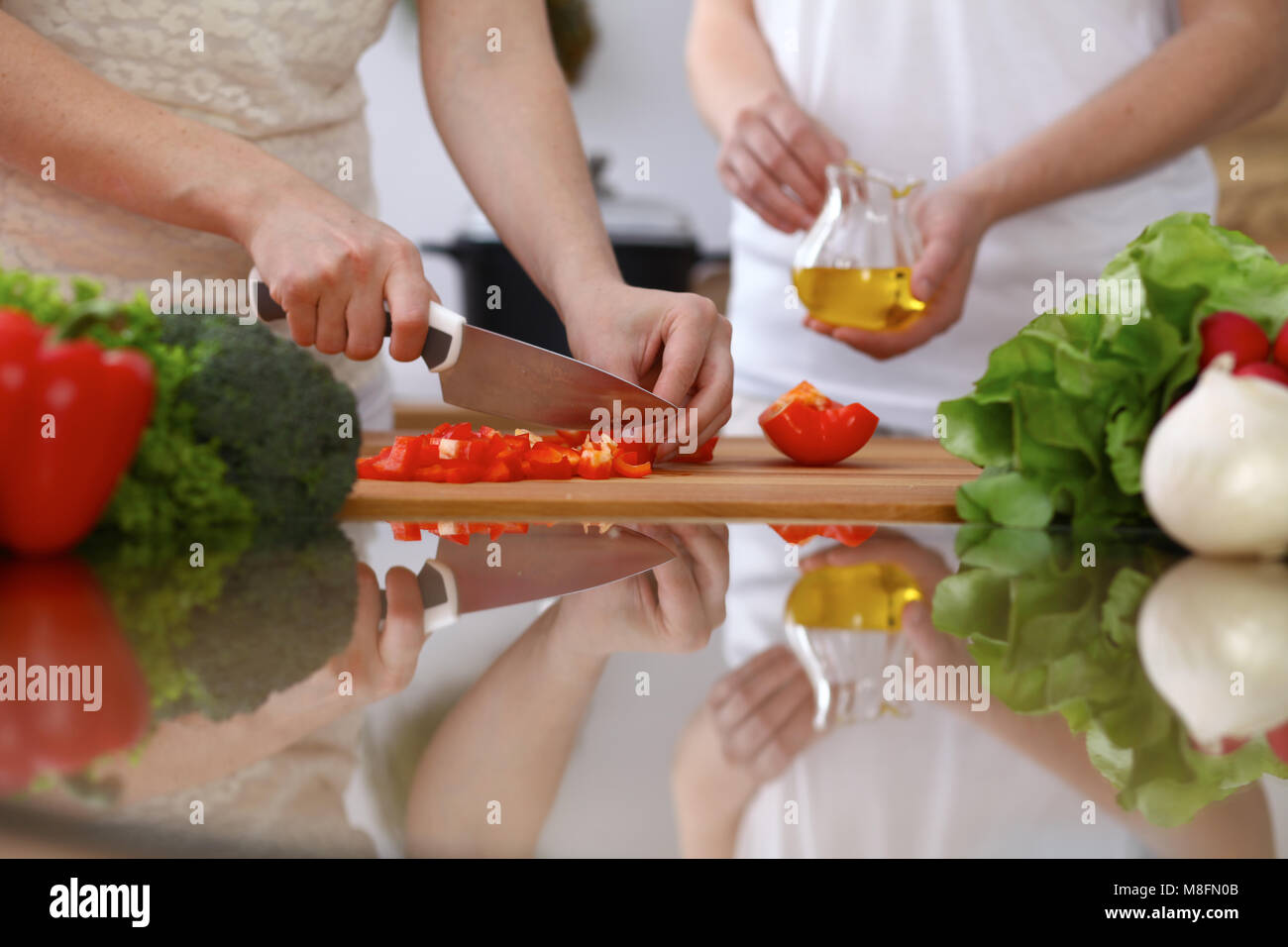 Closeup of human hands cooking in kitchen. Mother and daughter or two ...