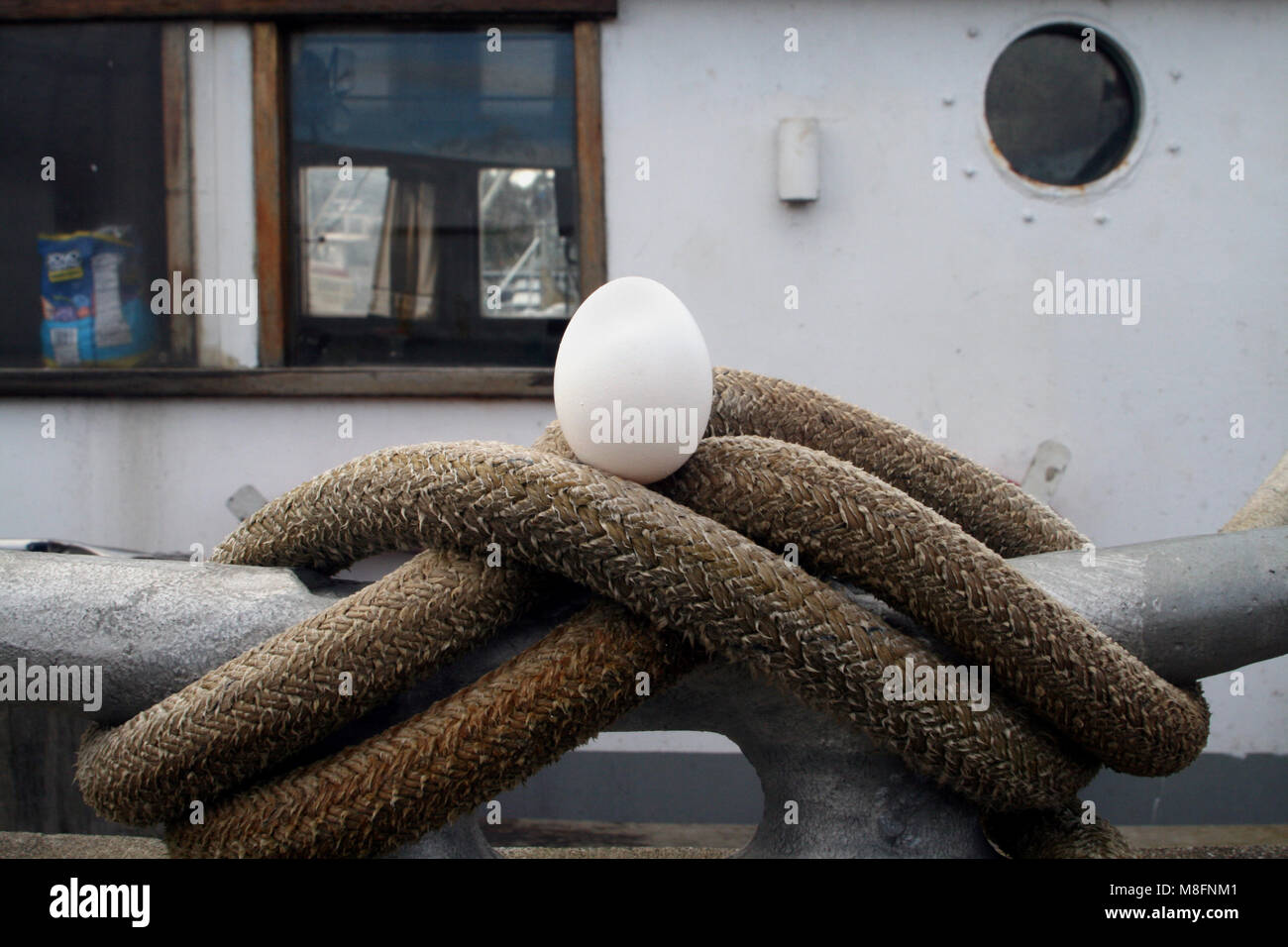 Egg on top of a rope tied to a metal cleat Stock Photo - Alamy