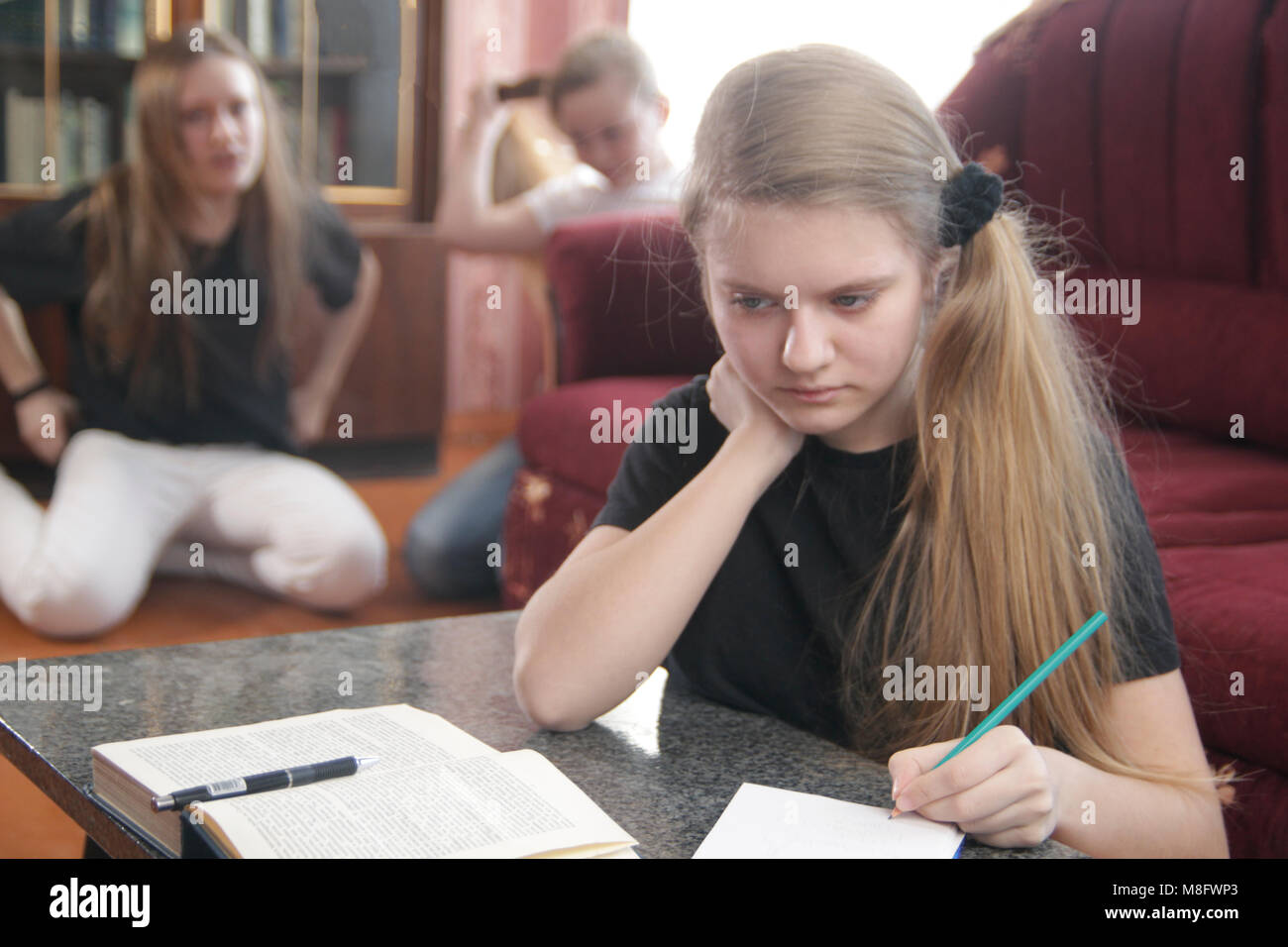 Girls teenagers plays and prevent to do homework Stock Photo - Alamy