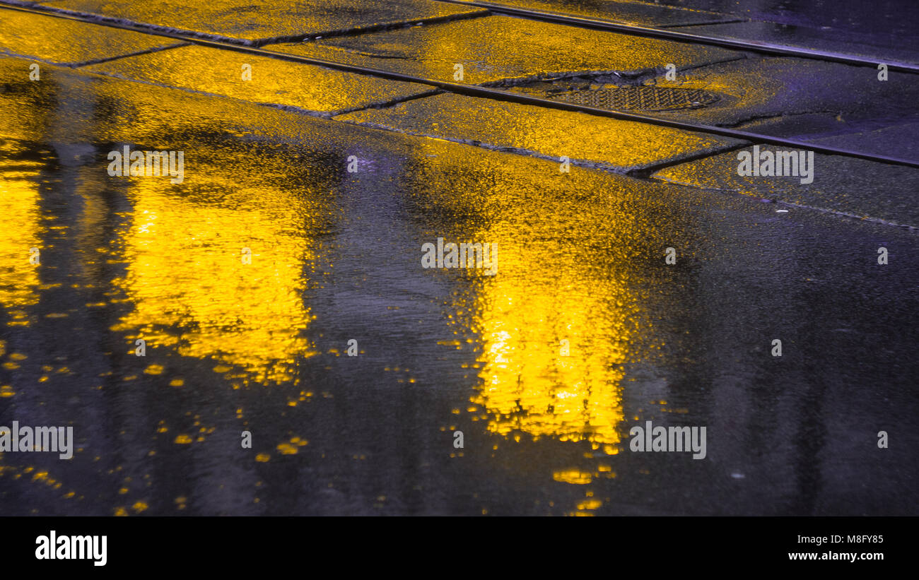 The bright lights of the evening city after rain, headlights from the ...