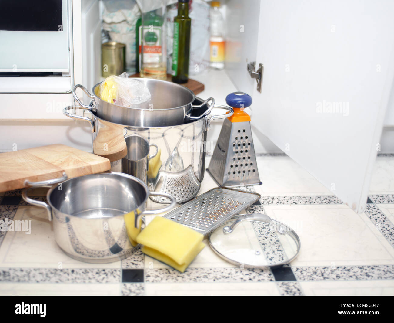 Kitchenware spread out on a floor and open kitchen cupboard Stock Photo ...