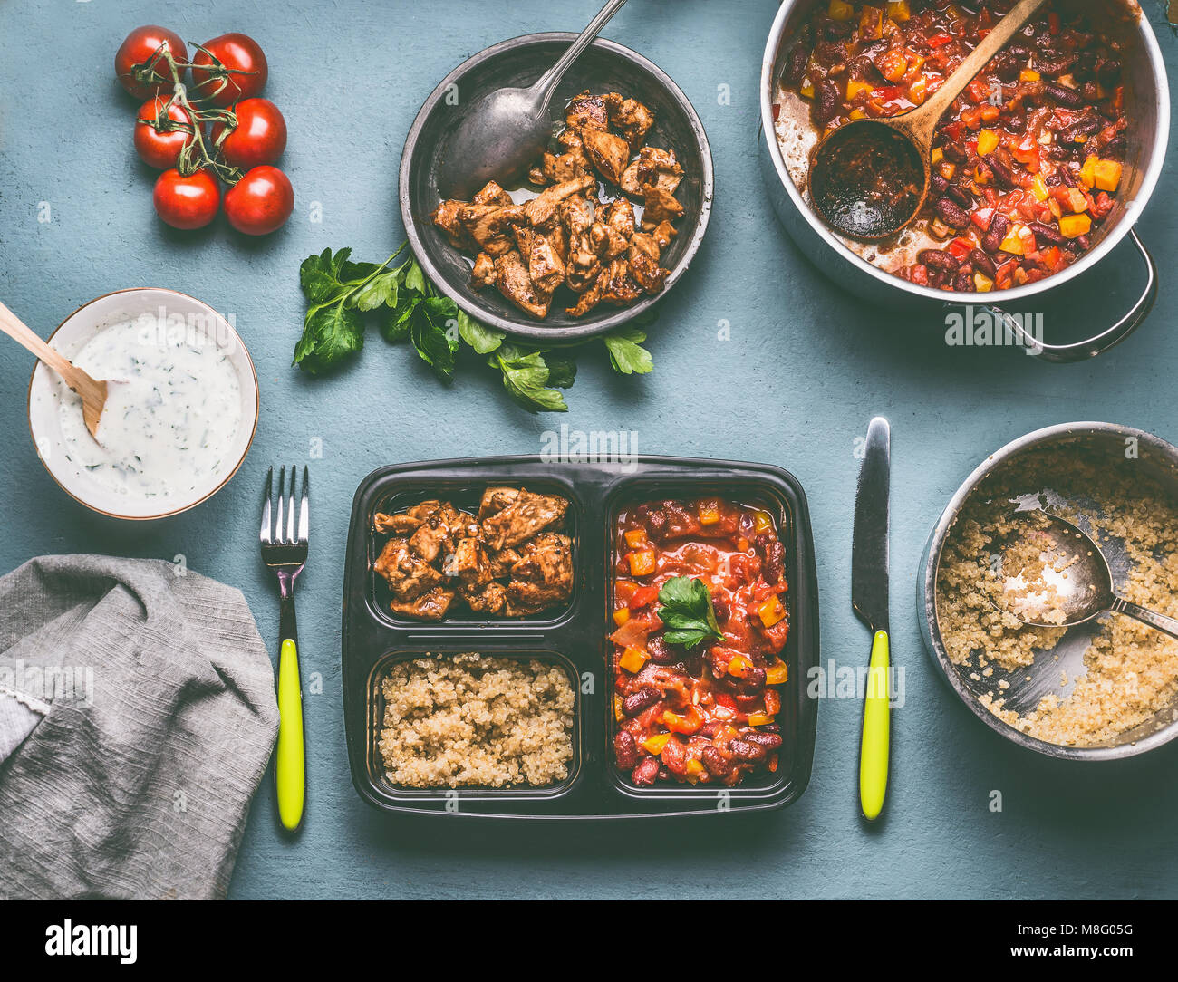 Healthy balanced lunch box preparation with quinoa, tomatoes beans ...
