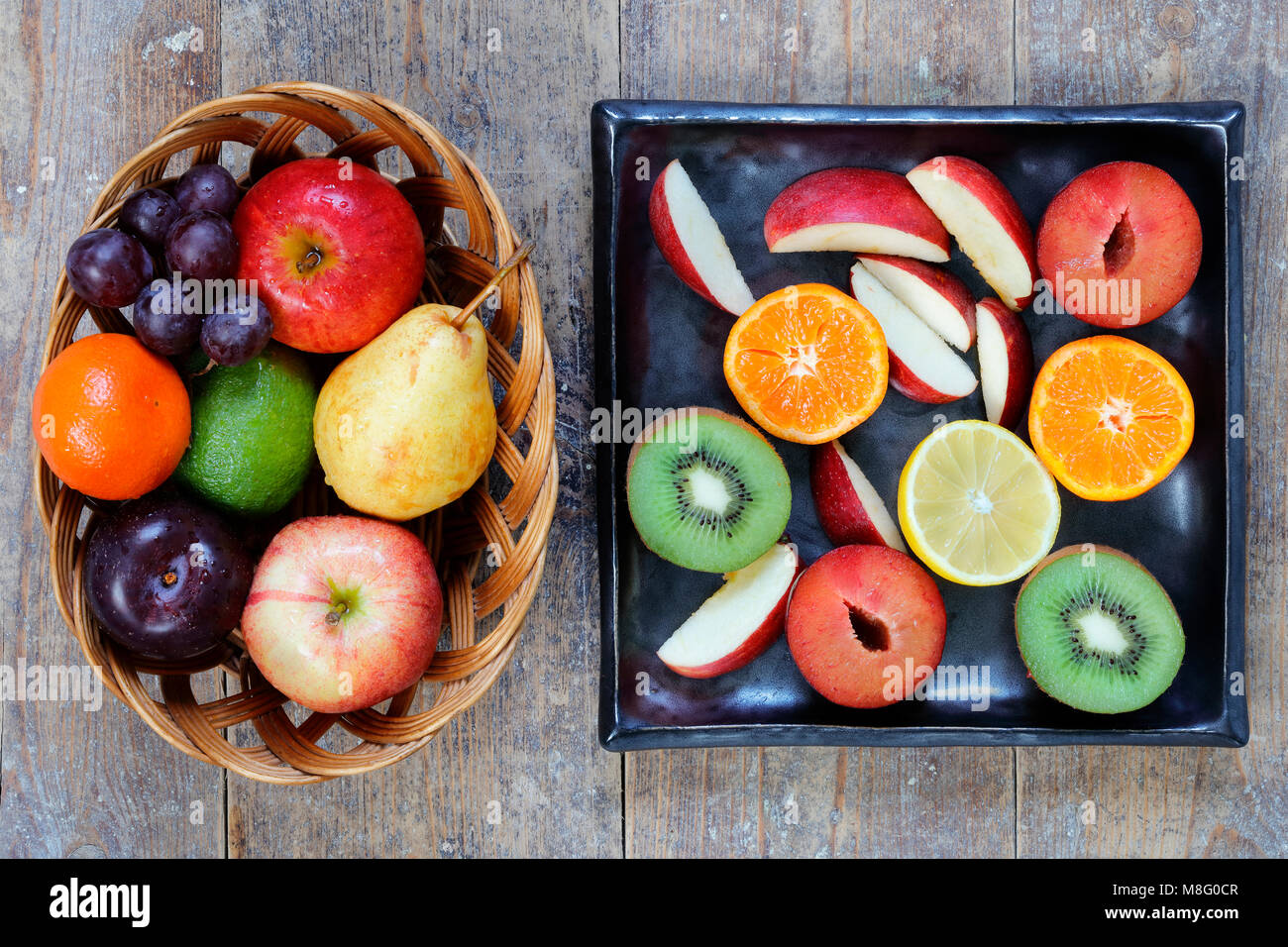 Whole and sliced fruits of apples, lime, lemon, pears and plums on ...