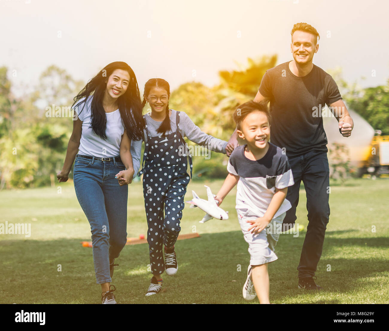 Family running with son and daughter having fun in summer park Stock ...