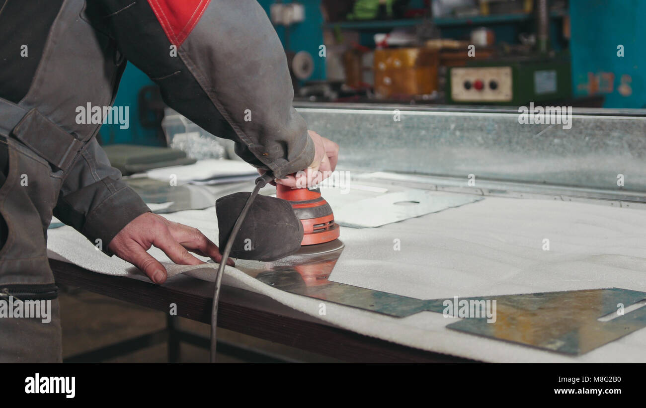 Close-up of a manual sander controlled by a worker at the factory and ...