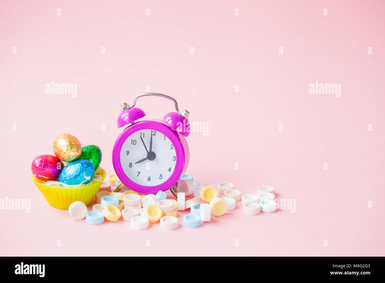 Easter Time Concept with alarm clock on color background Stock Photo ...