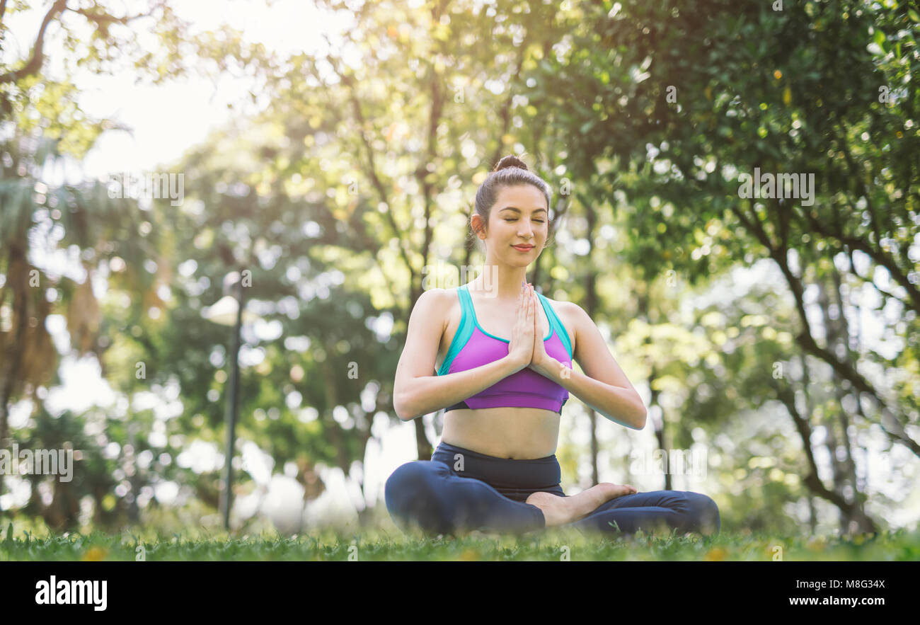 Yoga in the park healthy exercise. put the palms of the hands together ...