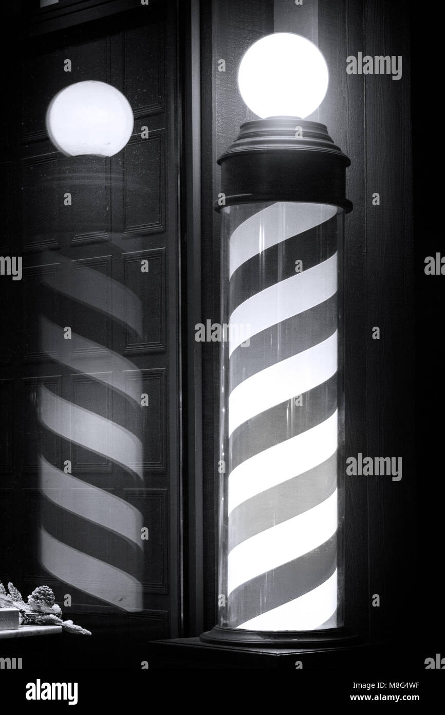A barbershop pole in reflects in the shop window in New York CIty ...