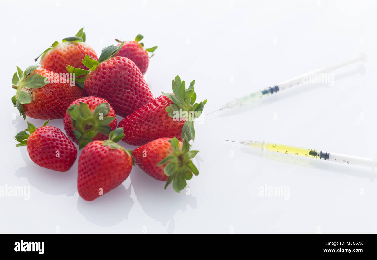 Modified food concept / strawberries with punched needles and syringes ...