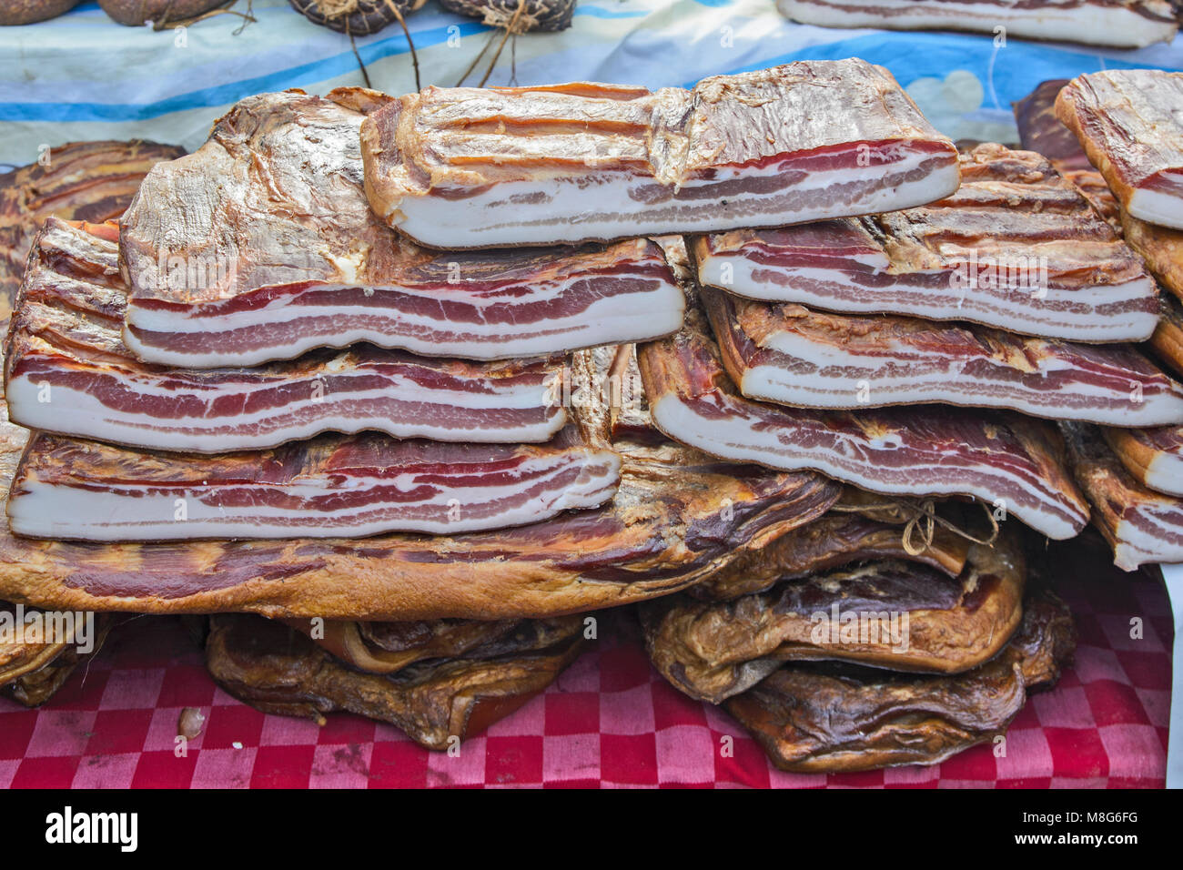 Homemade bacon on the table exposed for sale Stock Photo - Alamy