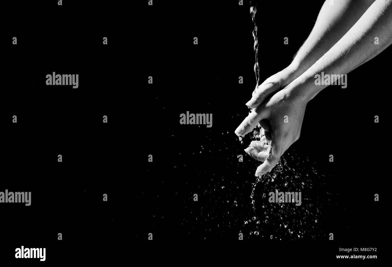 Woman's hands with water splash on black background Stock Photo - Alamy