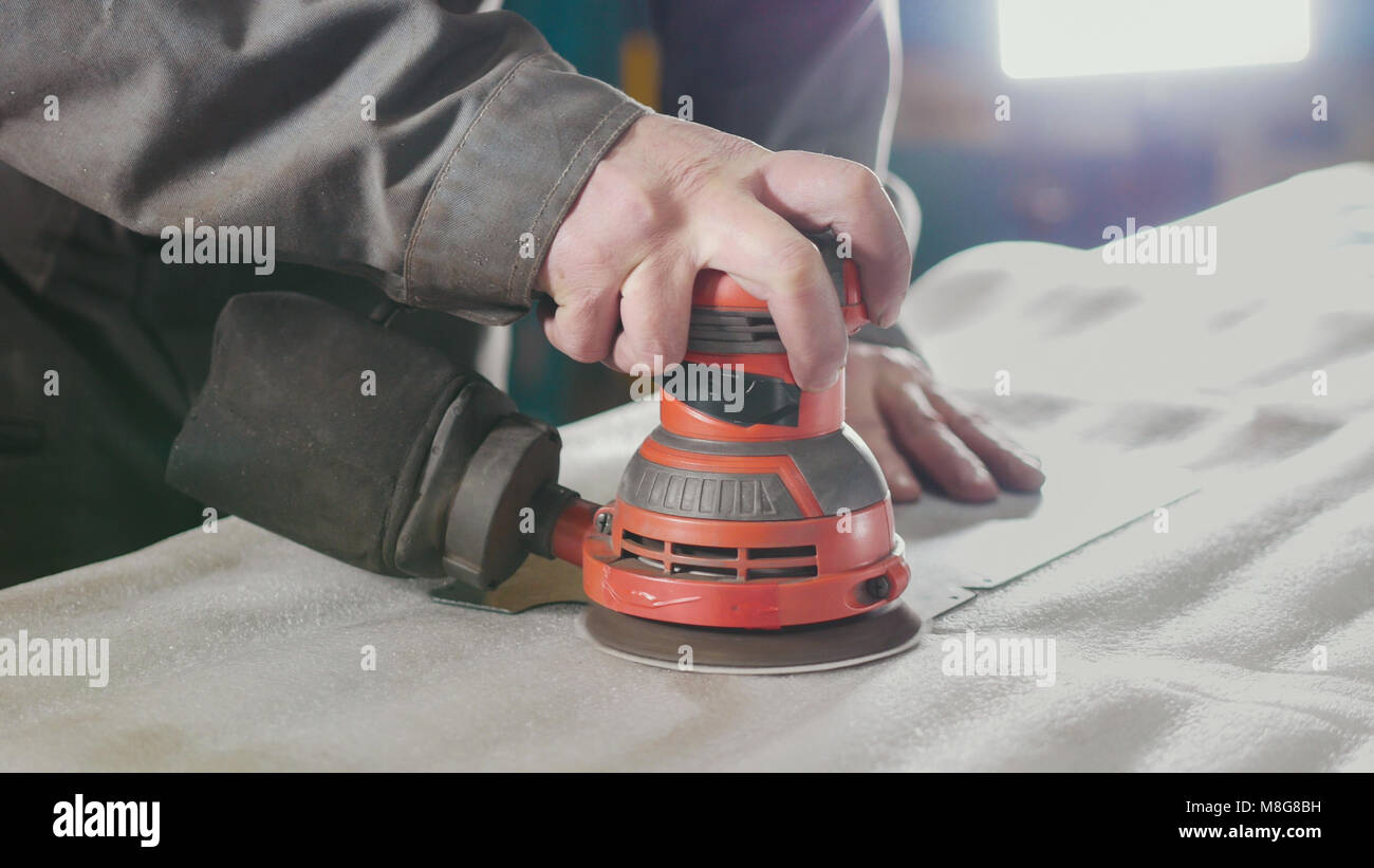 Close-up of a manual sander controlled by a worker at the factory and ...