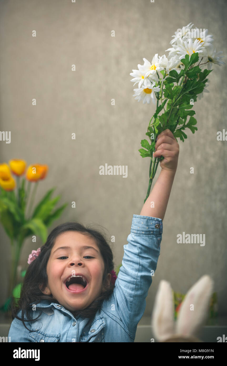 Portrait of a cute happy excited little girl with daisy flowers bouquet ...