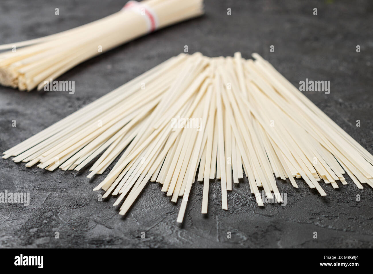 Raw Udon noodles for cooking Oriental and Asian cuisine on black ...