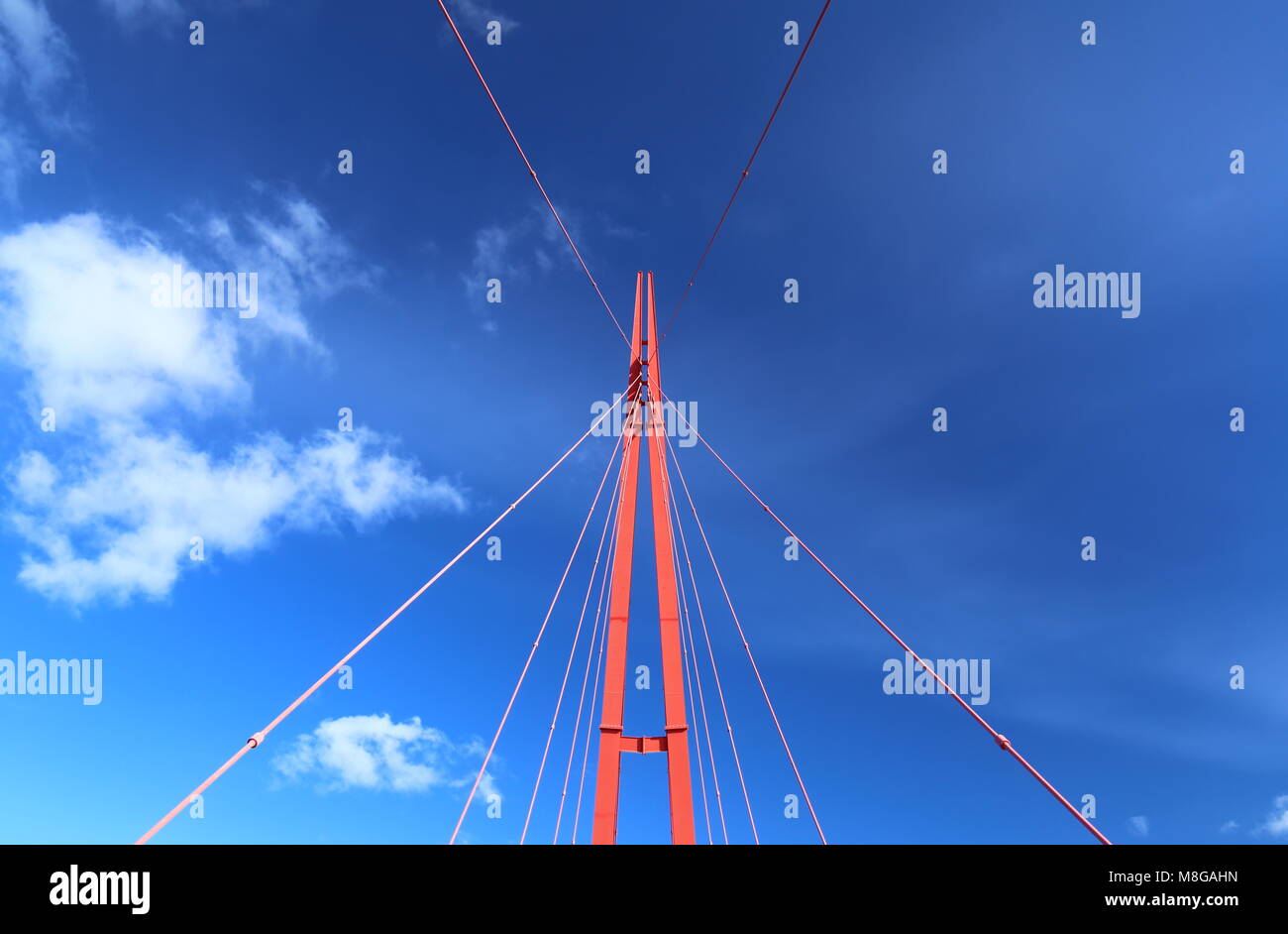 Symmetrical shot of suspension bridge on blue sky Stock Photo - Alamy