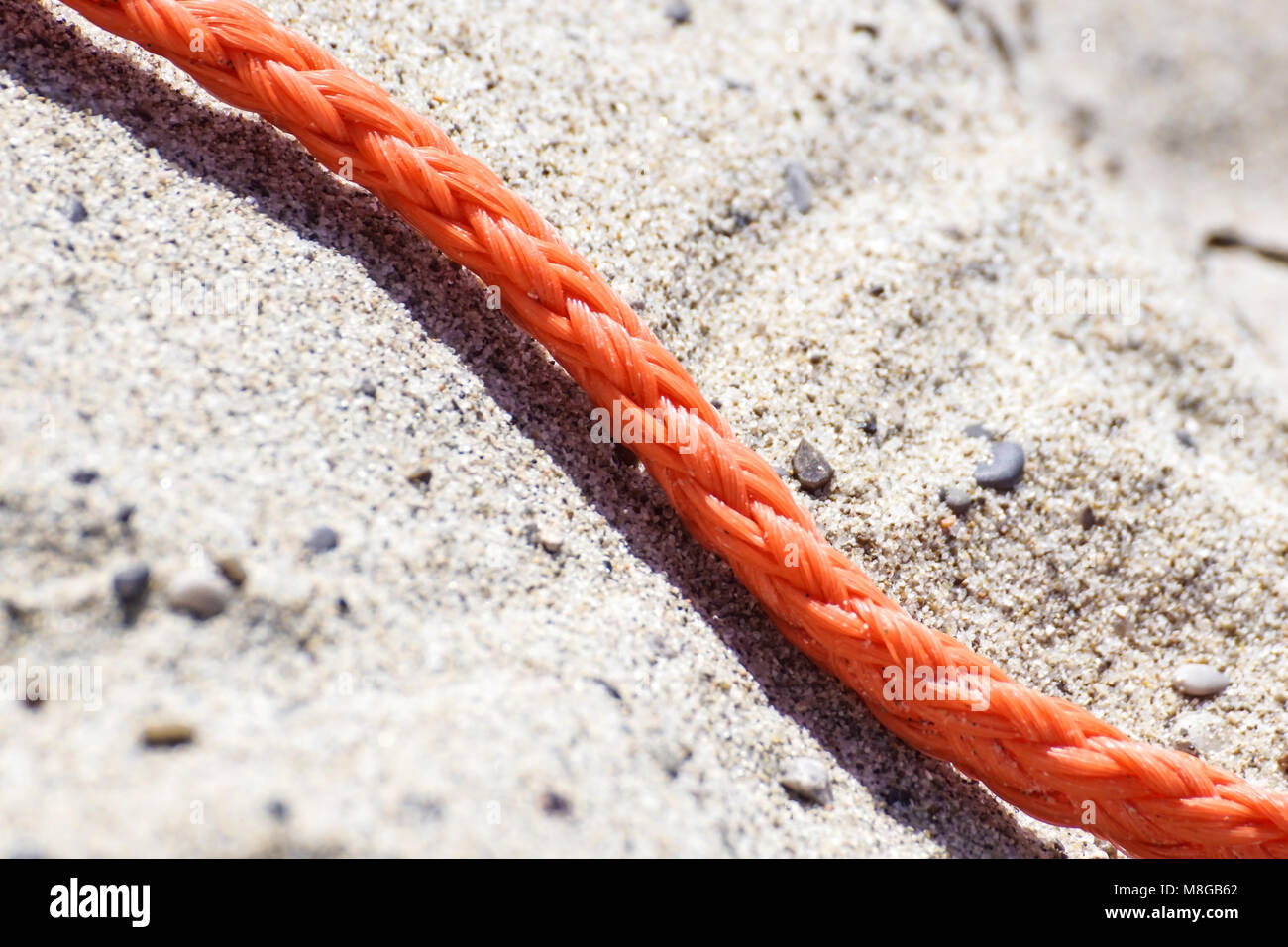 Old thick nautical rope on the sand ground Stock Photo - Alamy