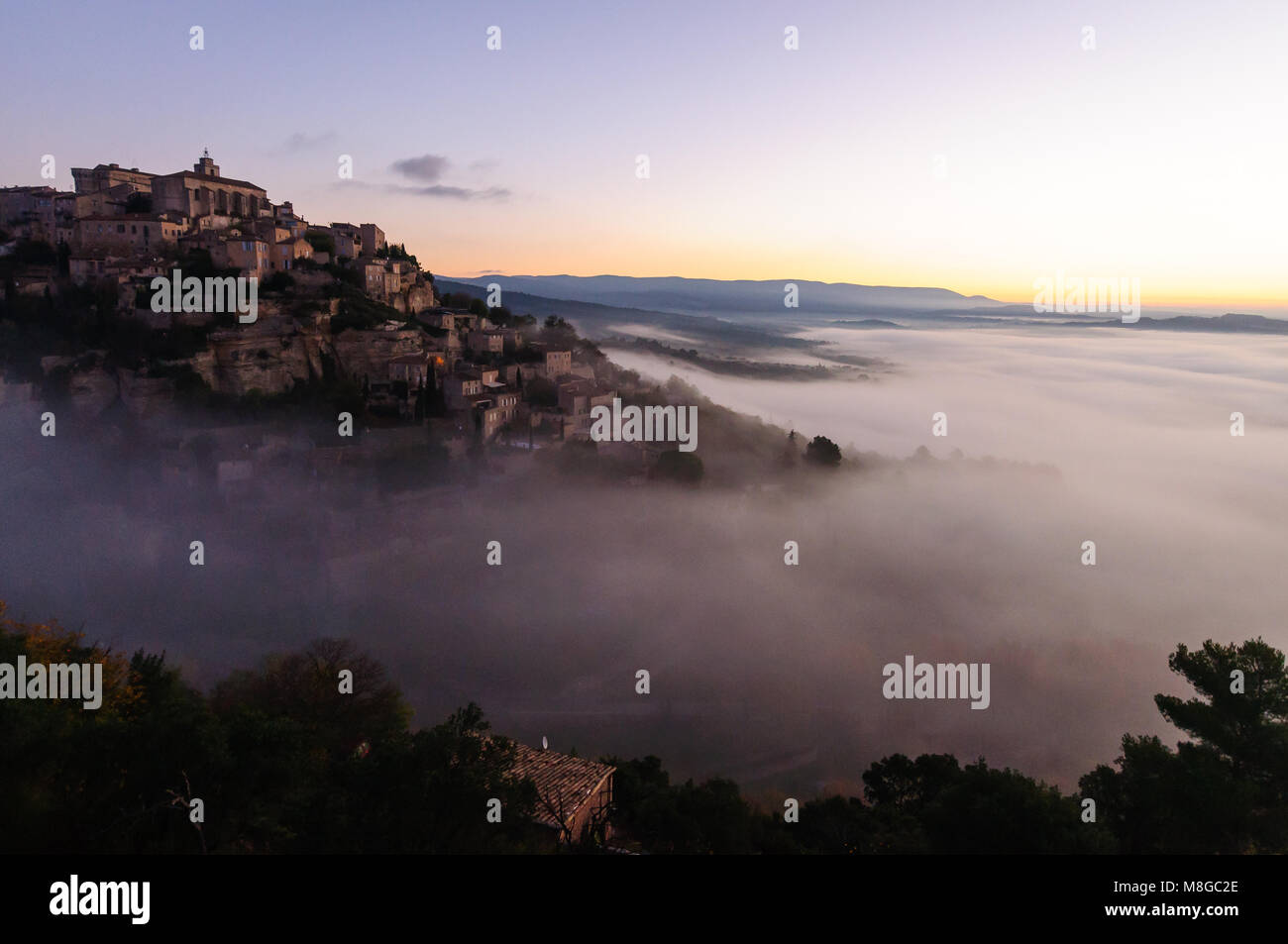 Hill village rising out of the morning mist/fog Stock Photo - Alamy