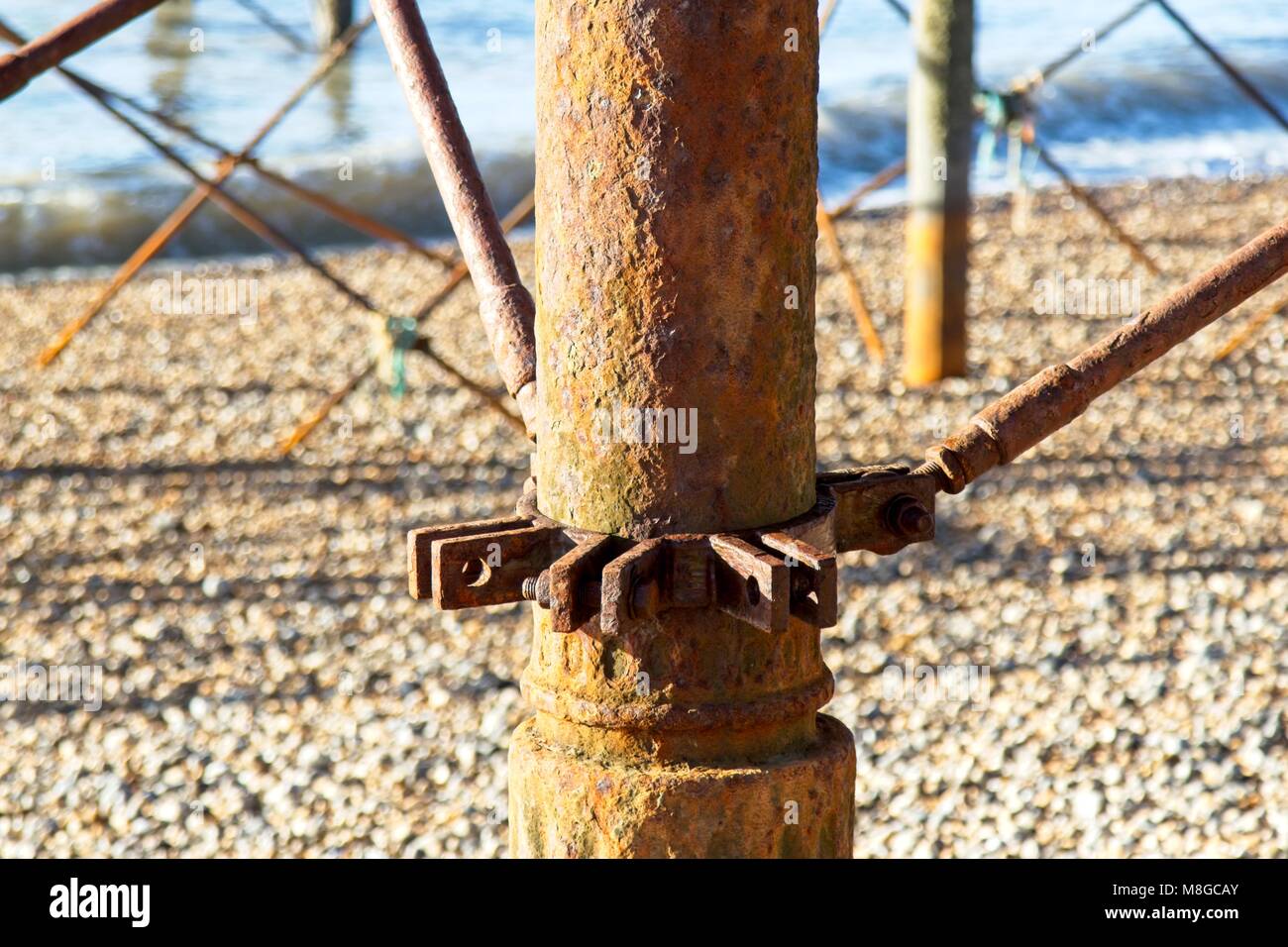 Rusty metal pier support on pebble beach Stock Photo - Alamy