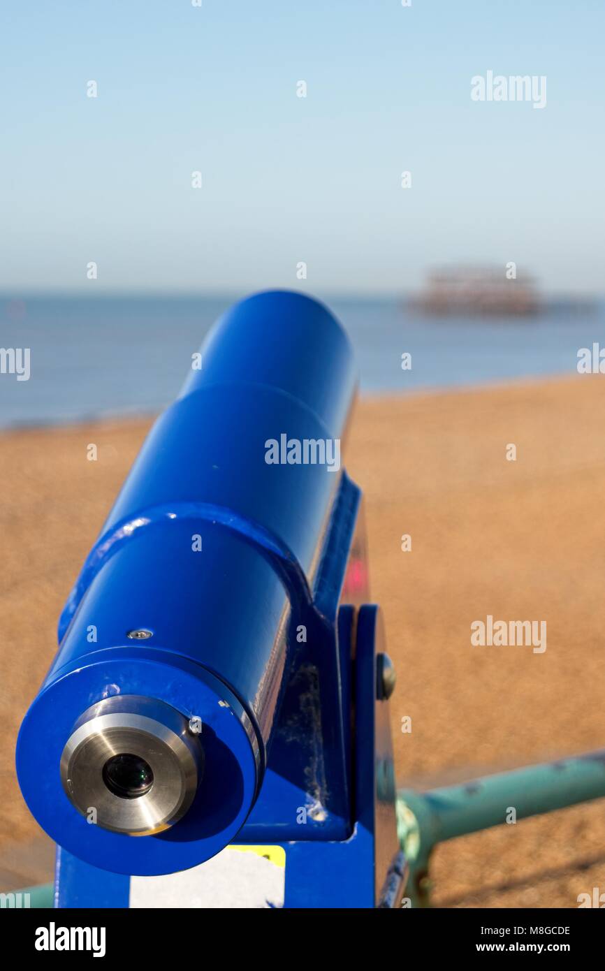 Telescope viewer pointing toward Brighton West Pier across pebble beach ...