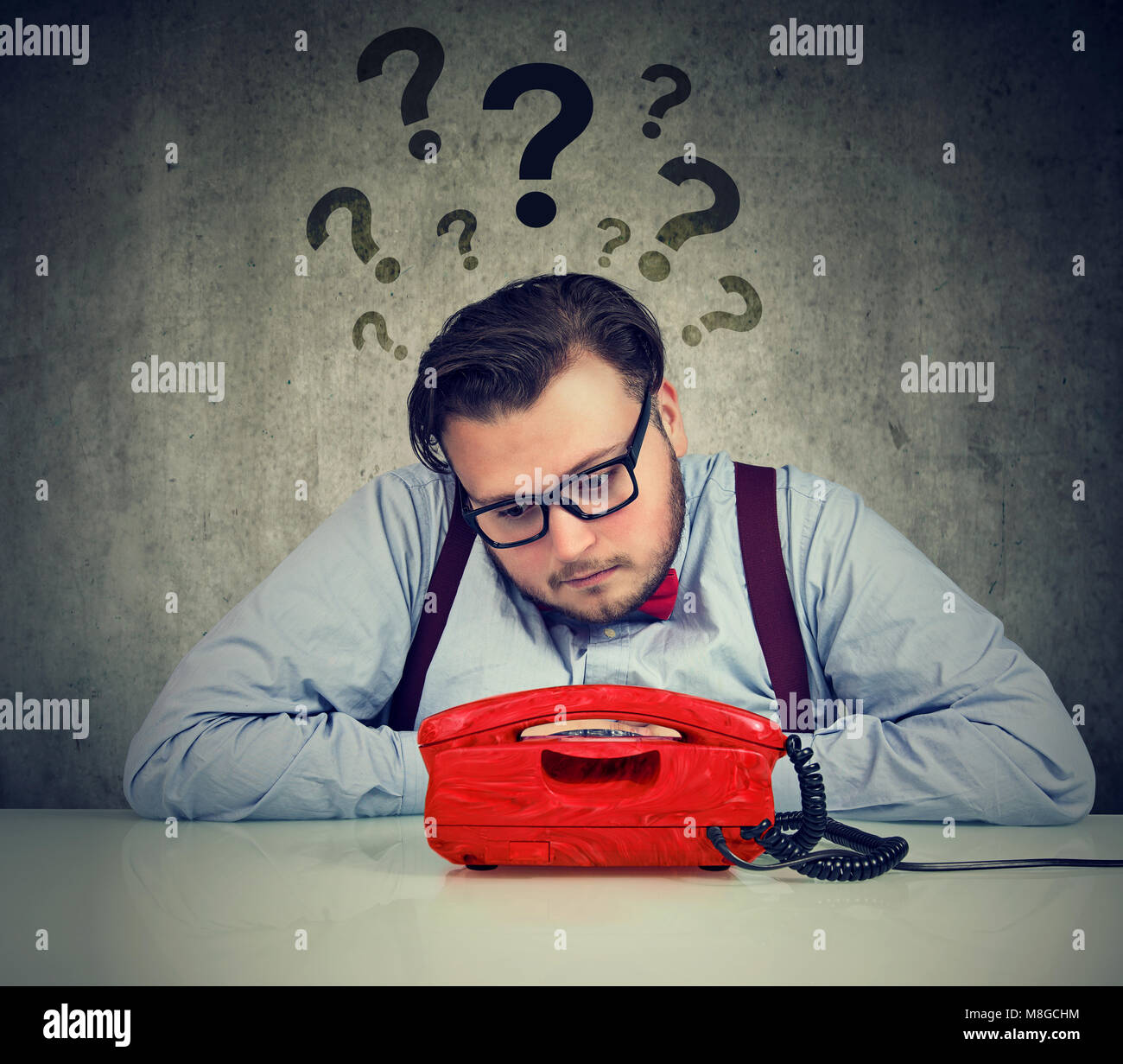 Sad man with too many questions waiting for a call Stock Photo - Alamy